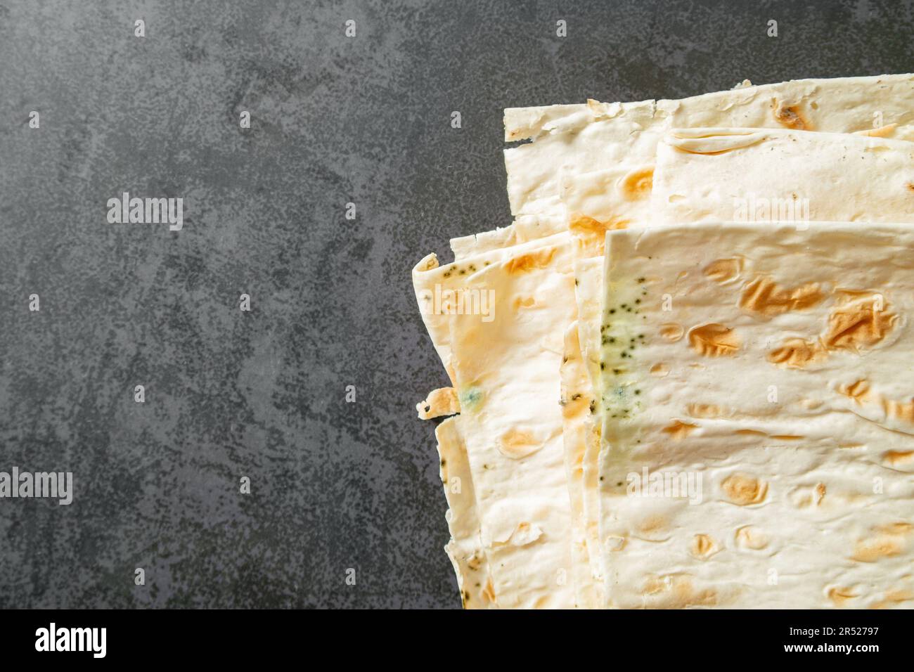 Spoiled pita, moldy. Mildew on the bread. Gray background. copy space ...