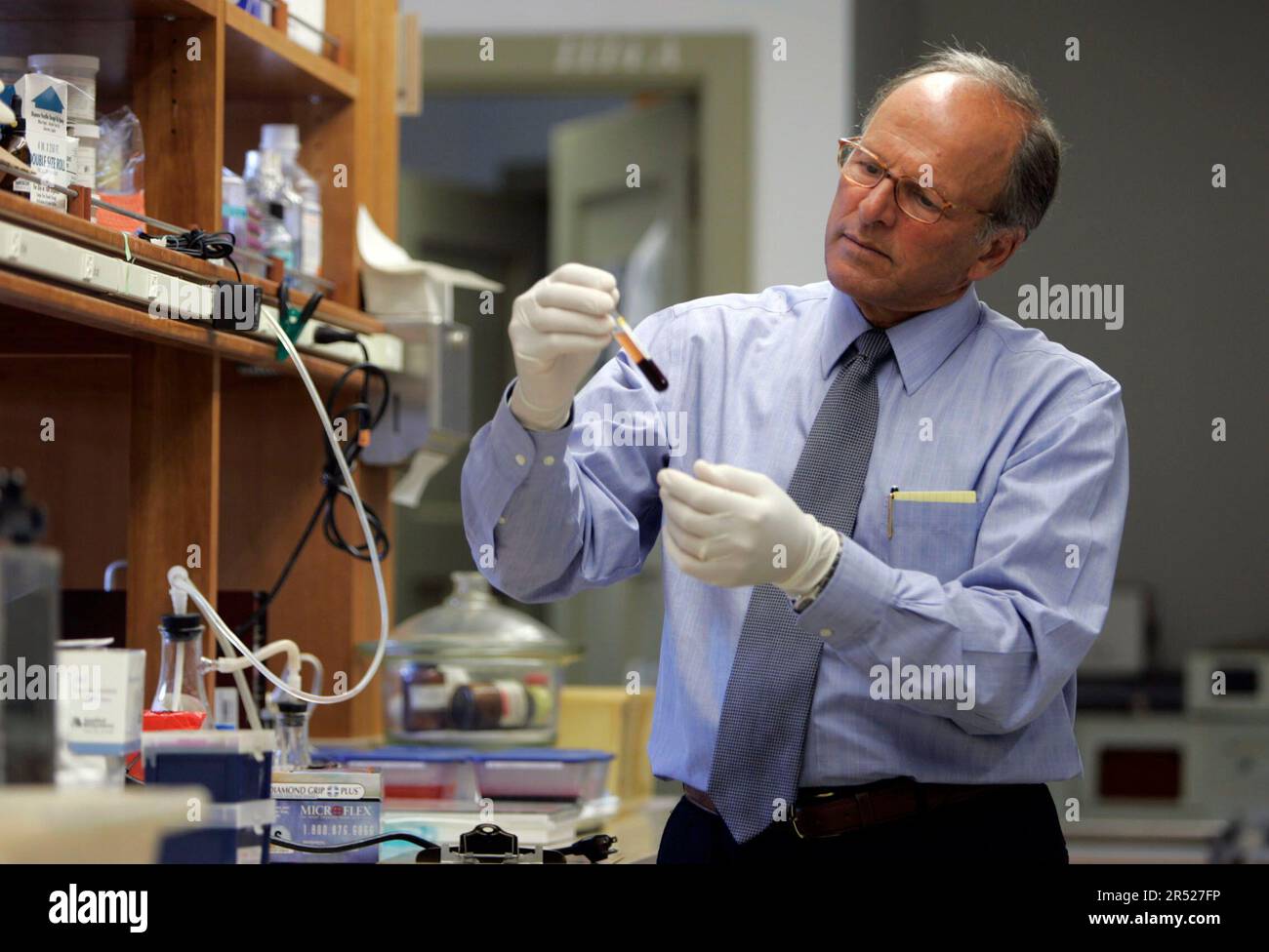 cordblood 057 pc.jpg Dr. Bertram Lubin examines a blood sample at ...