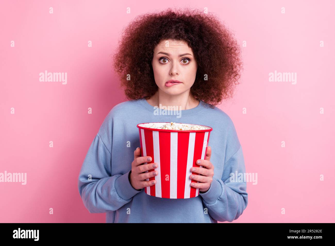 Photo of doubtful scared lady dressed blue pullover biting lip eating ...