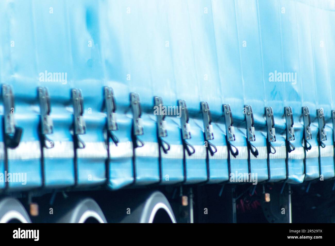 Straps on the side of an articulated lorry flap around in the wind ...