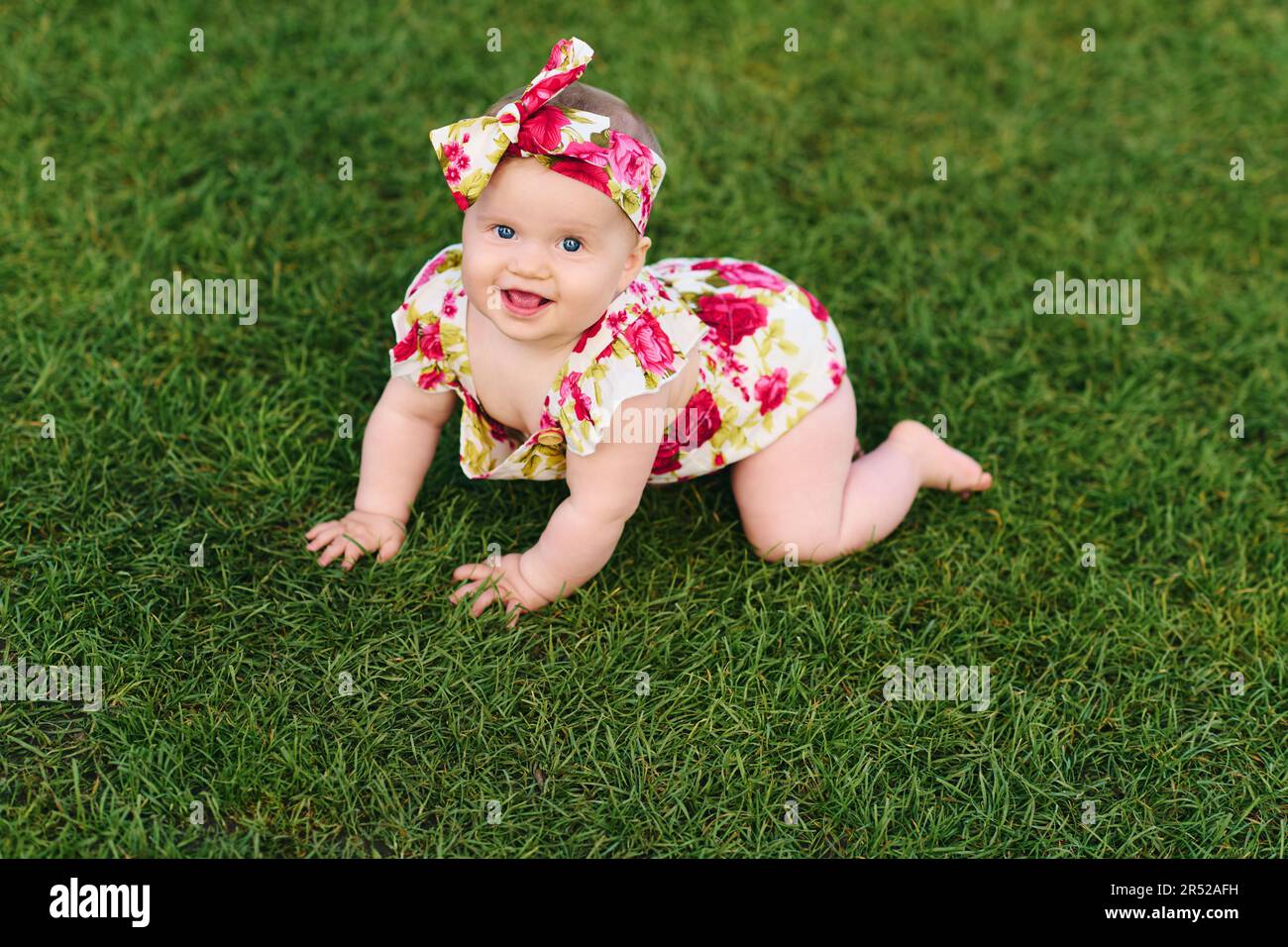 Outdoor portrait of adorable 6 months old baby girl playing in summer ...