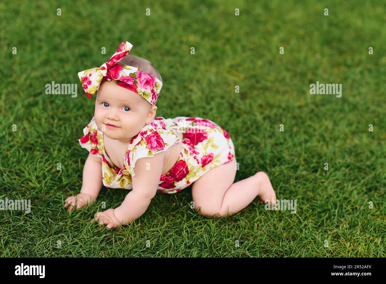 Outdoor portrait of adorable 6 months old baby girl playing in summer ...