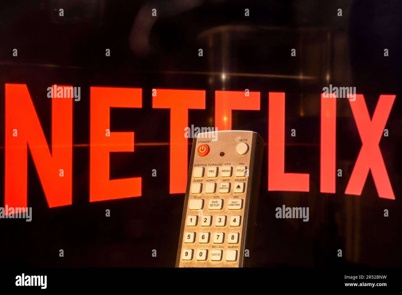 Remote control in front of a TV on which you can see the Netflix logo ...