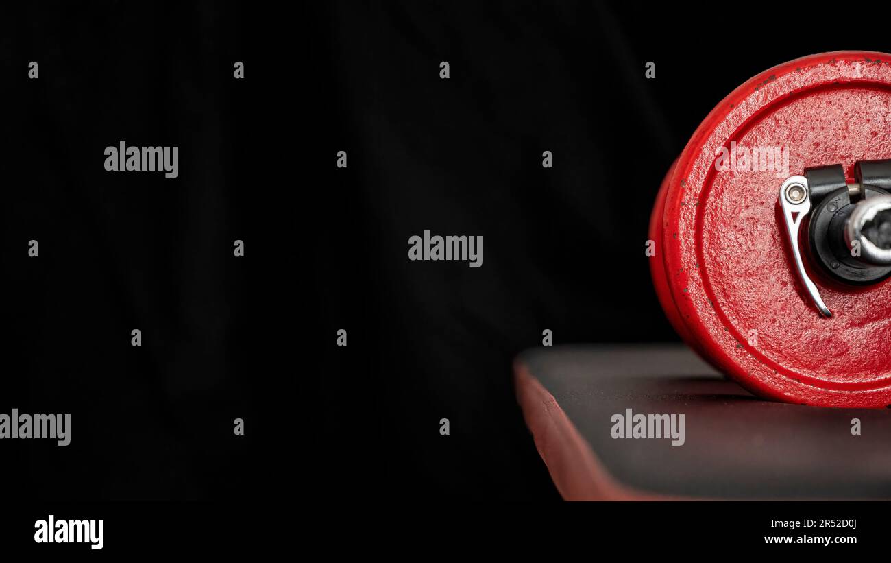 Dumbbell with red weights on a black weight training bench ready to use ...