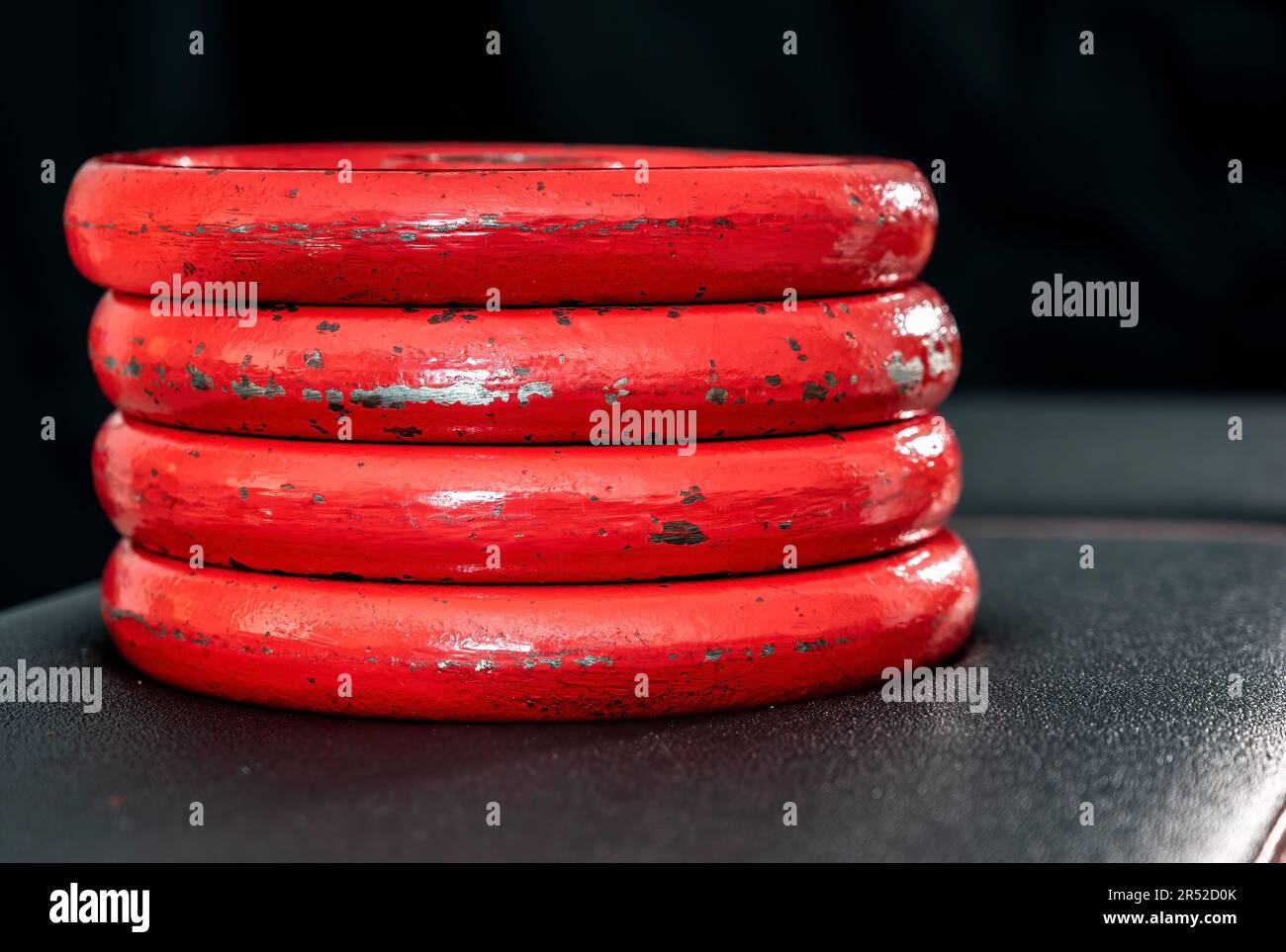 Stack of red weights on a black weight training bench ready to use on a ...
