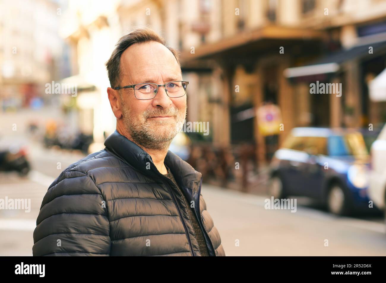 Outdoor portrait of middle age man in city, wearing blue jacket and ...