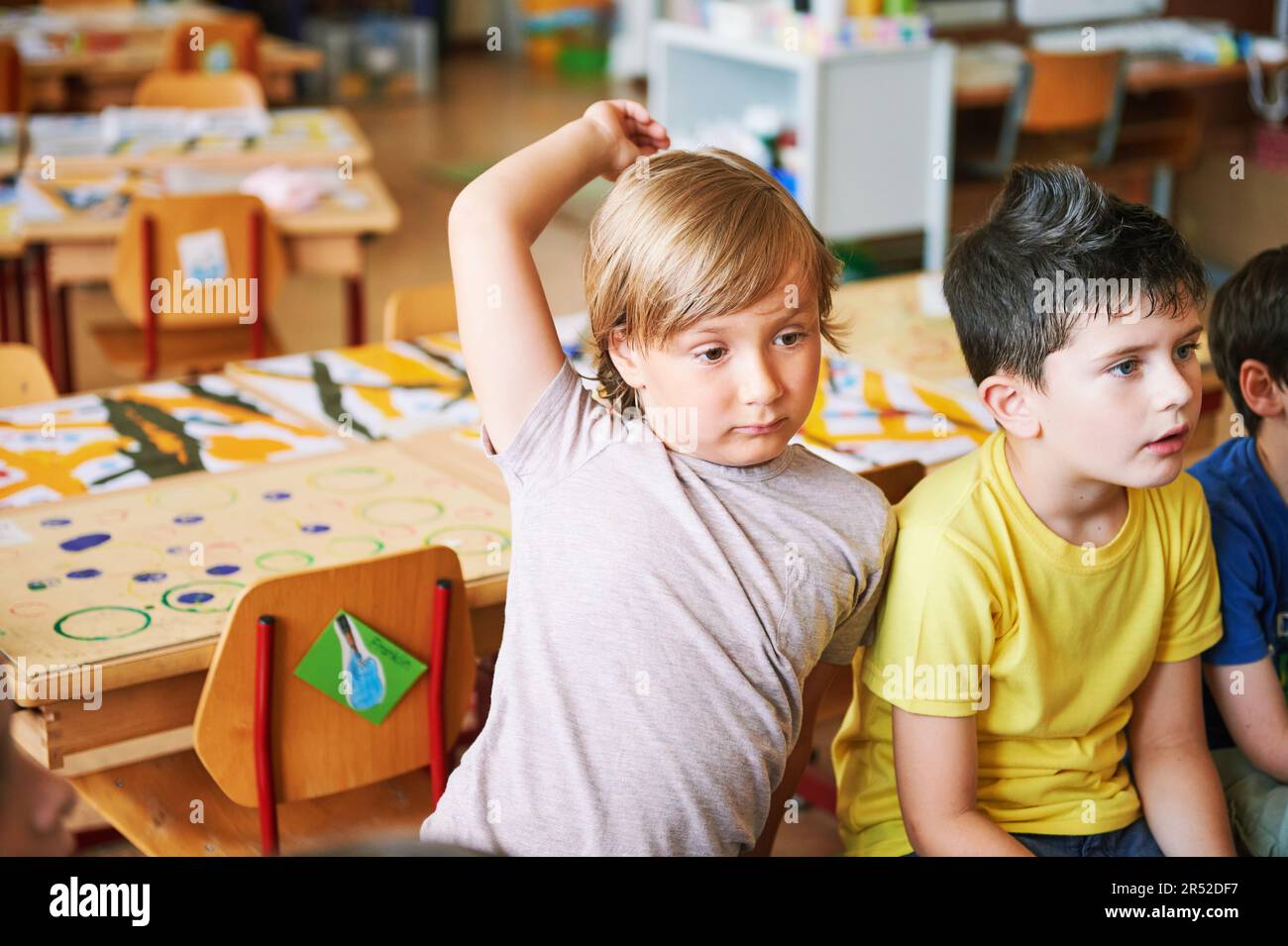 Two concentrated 4-5 year old boys in classroom, preschool children ...