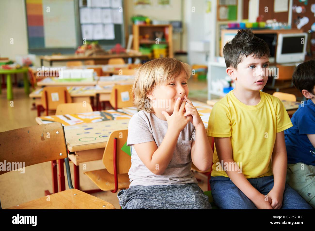 Two concentrated 4-5 year old boys in classroom, preschool children ...