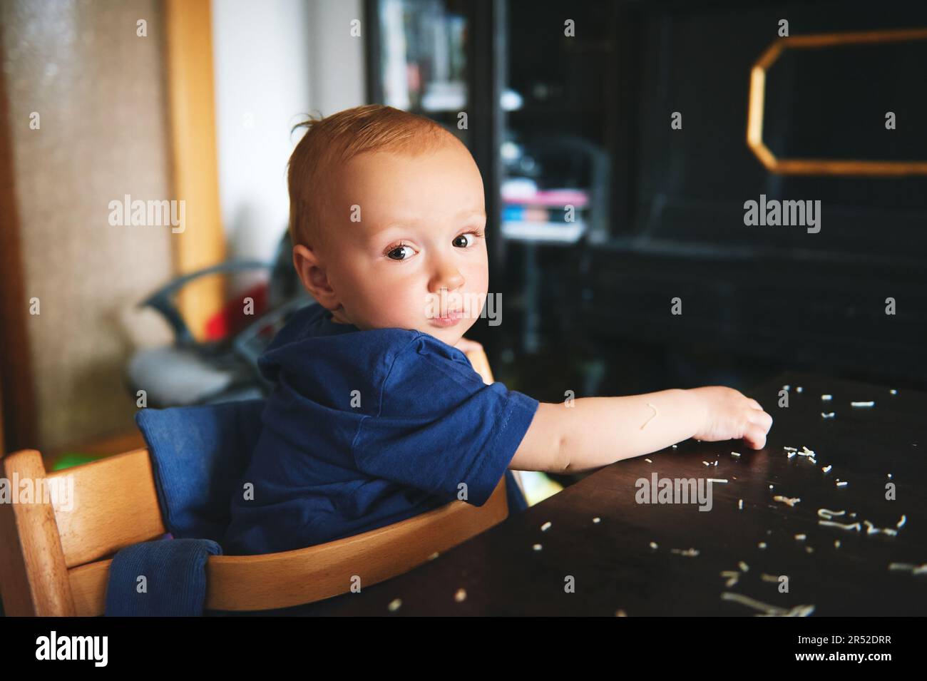 Messy baby smeared pasta on the table, toddler kid eating by himself ...