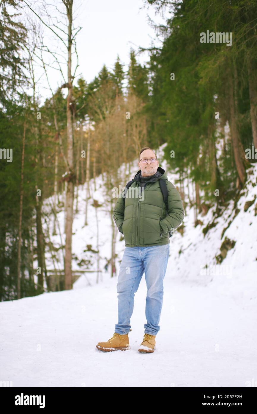 Outdoor portrait of middle age 55 - 60 year old man hiking in winter ...