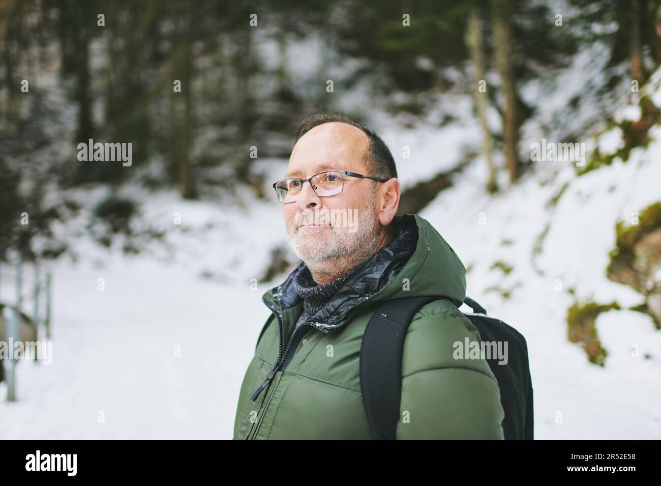 Outdoor portrait of middle age 55 - 60 year old man hiking in winter ...