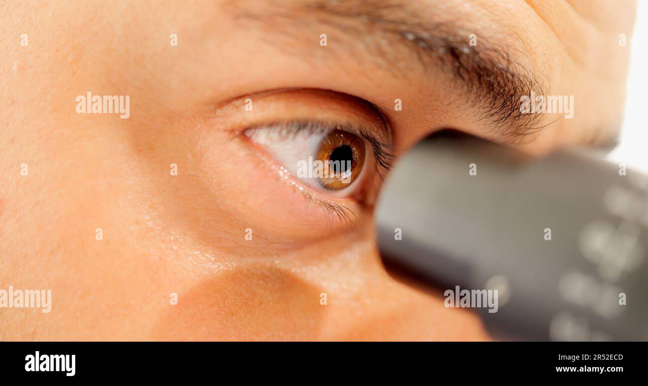 Professional male scientist looking through microscope in laboratory ...