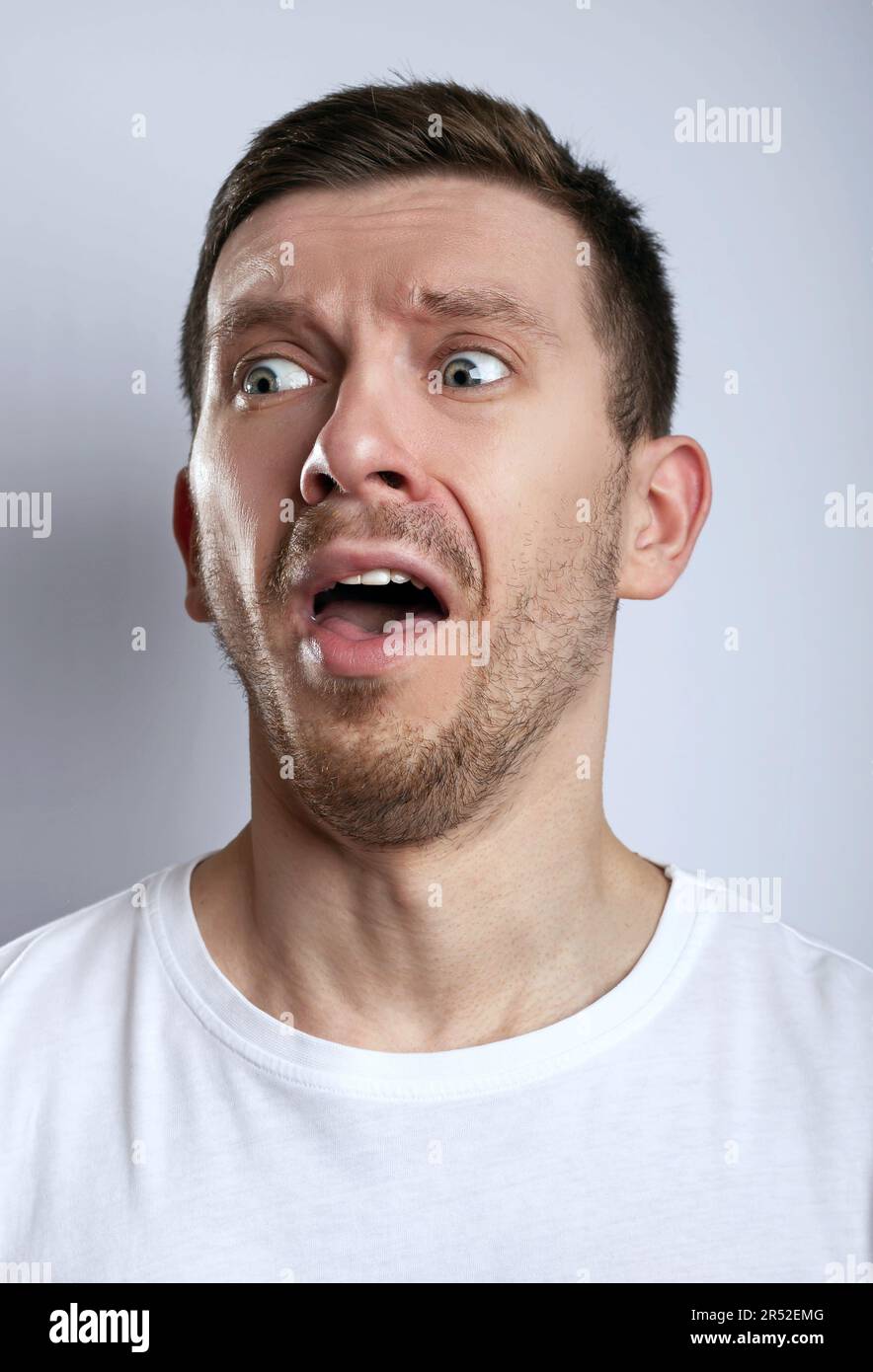 Emotional scared male looks with frightened expression as sees ...