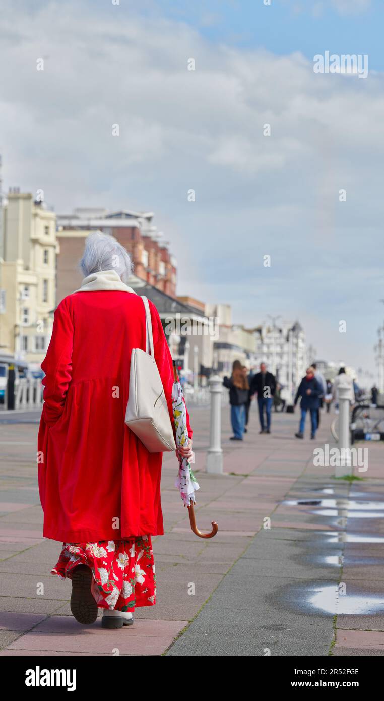 A smartly dressed woman on the promenade at Brighton and Hove, south ...