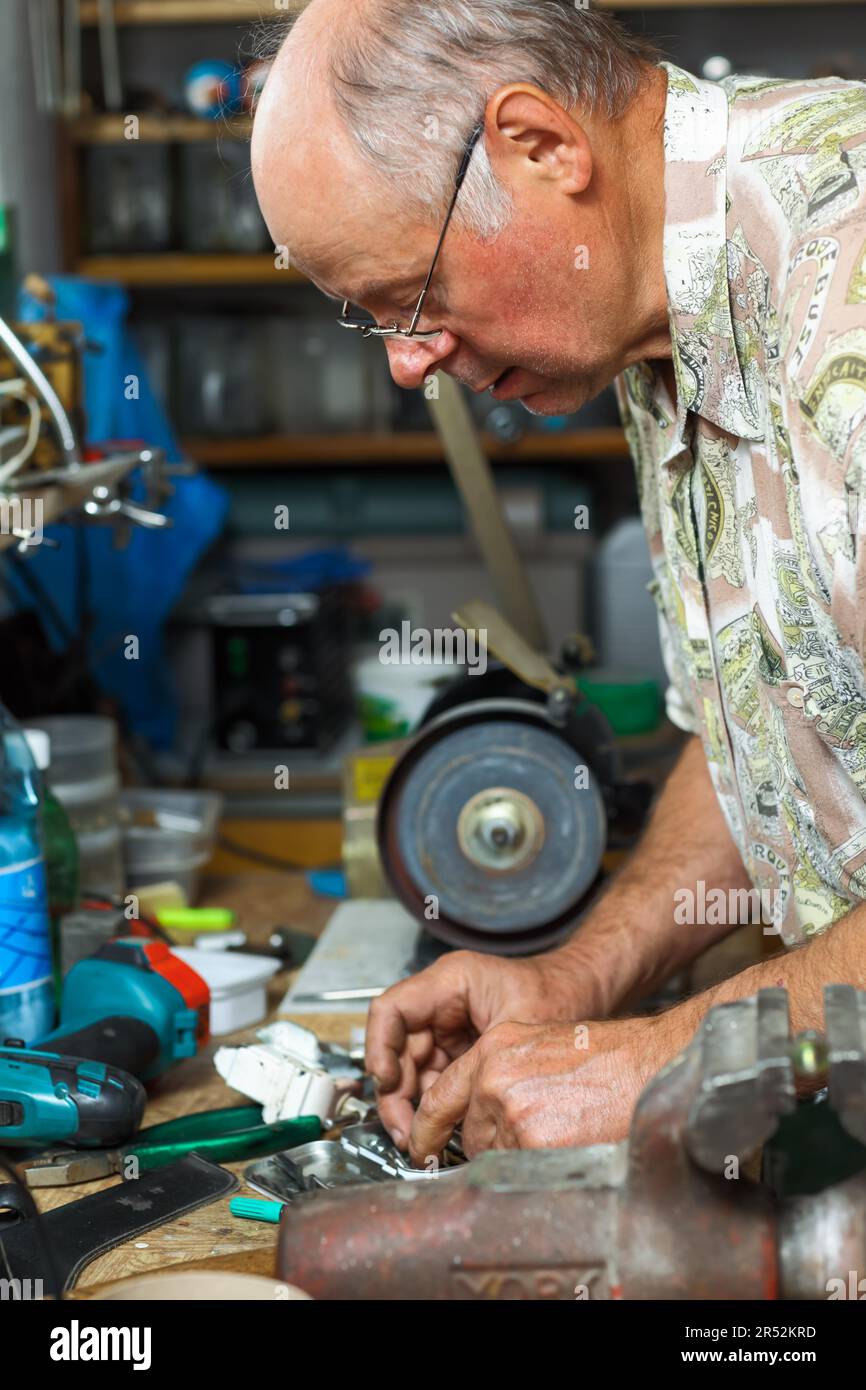 Senior working in workshop with different tools Stock Photo - Alamy