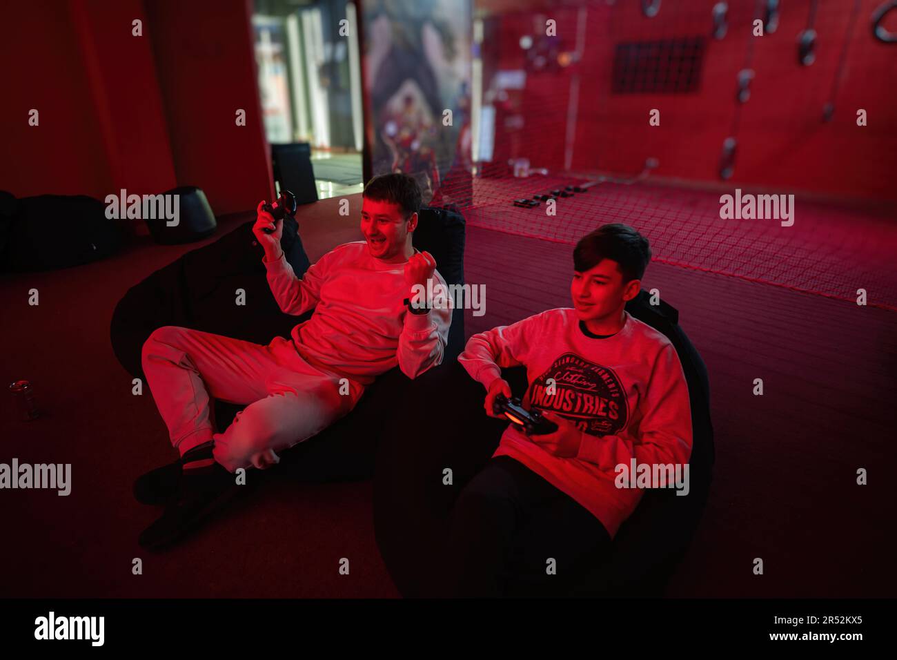 Yes, i am winner! Father and son play gamepad video game console in red ...
