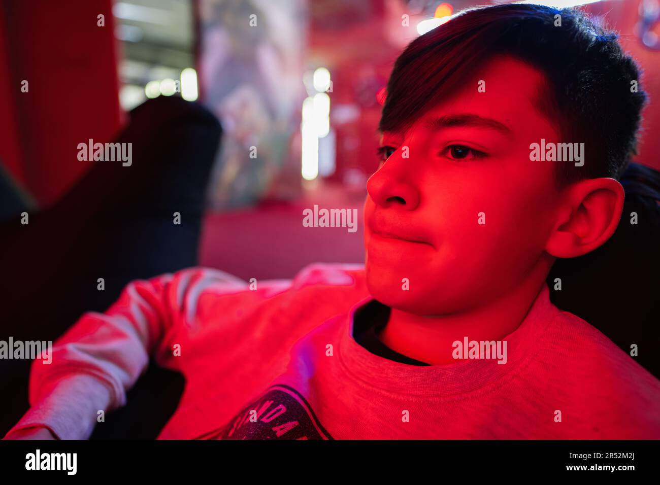 Teenager boy gamer play gamepad video game console in red gaming room ...