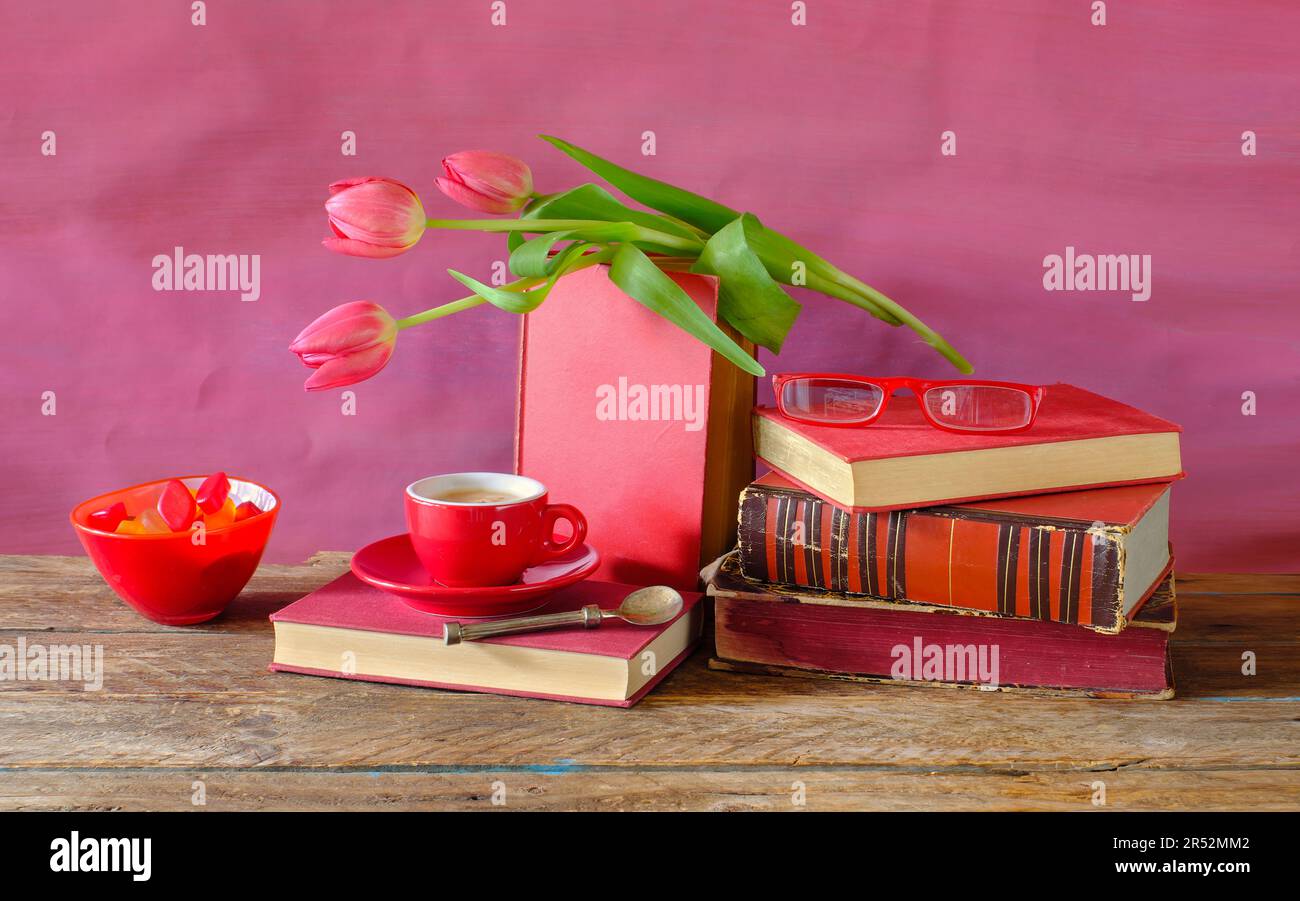 stack of books, espresso coffee and tulips, reading and education in ...