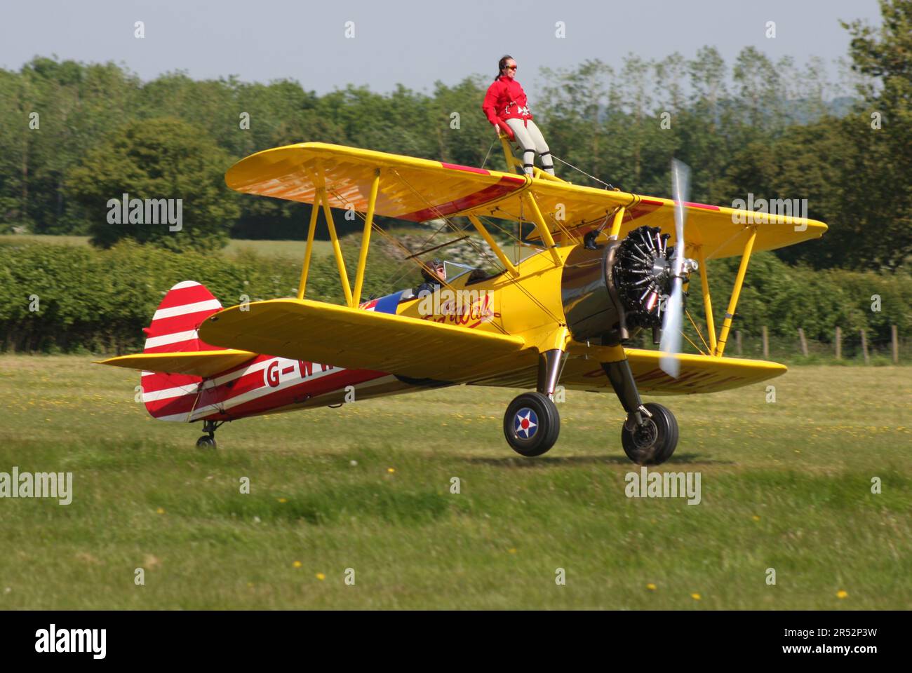 A Boeing A-75L300 Stearman biplane of The Wing Walk Company in action ...