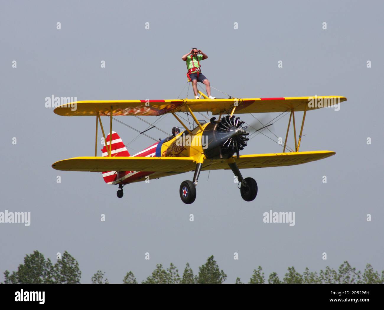 A Boeing A-75L300 Stearman biplane of The Wing Walk Company in action ...