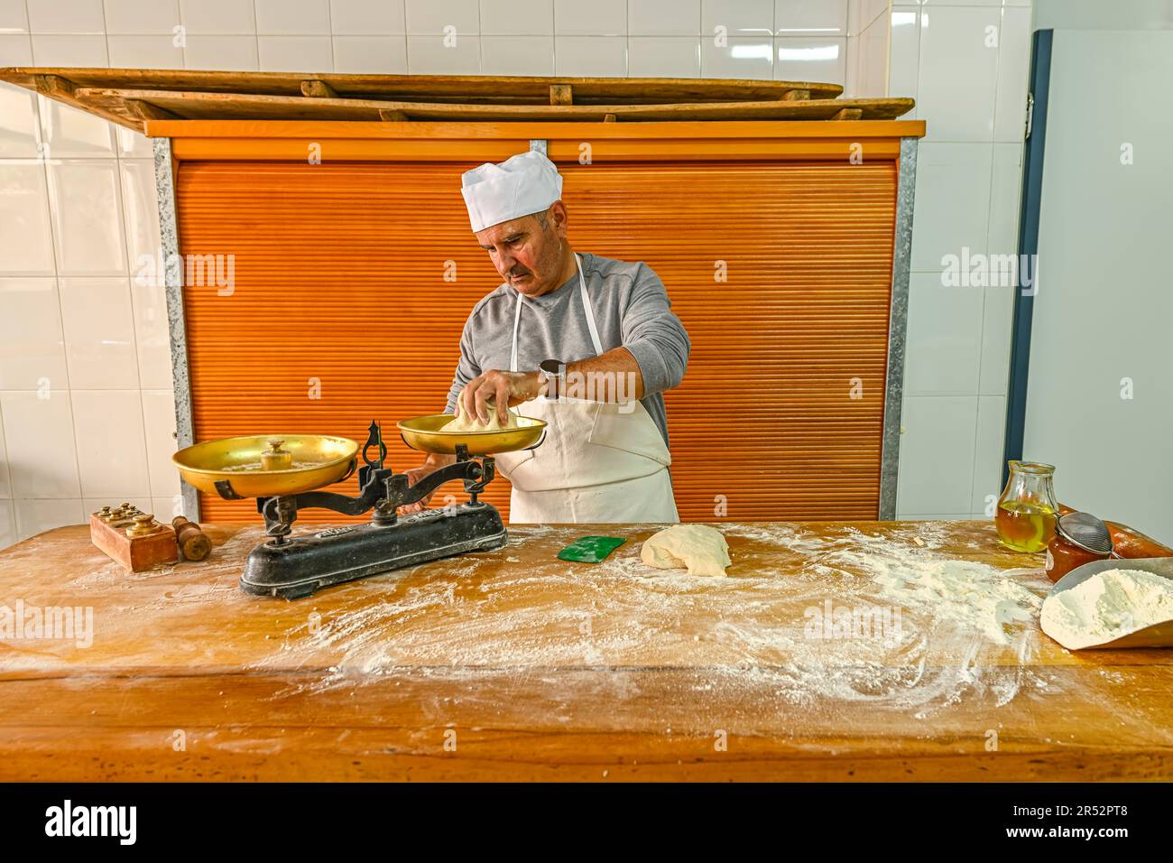 Baker cutting and weighing dough, for the preparation of bread Stock ...
