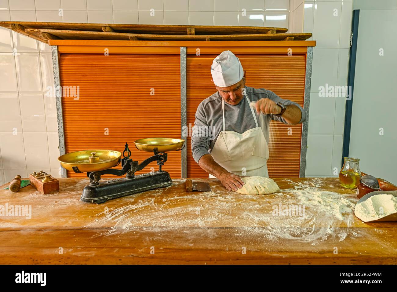 Baker cutting and weighing dough, for the preparation of bread Stock ...