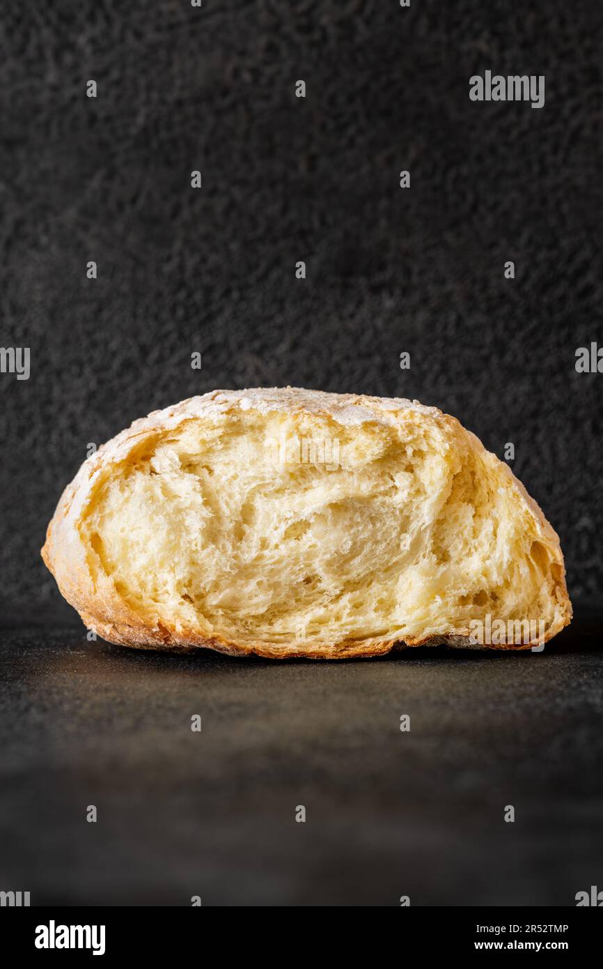 Broken loaf of bread on black background Stock Photo - Alamy