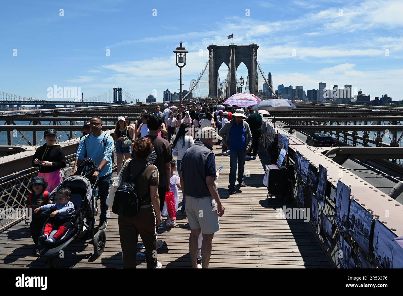 A crowd works their way past vendors lining the pedestrian walkway on ...