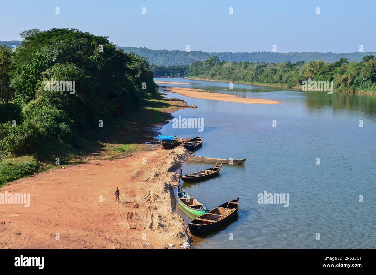 River with lush green river bank and sand mining boats at Polali ...