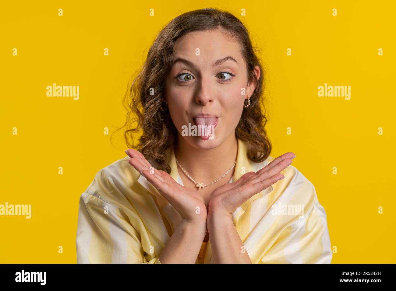 Funny comical playful young woman making silly facial expressions and ...