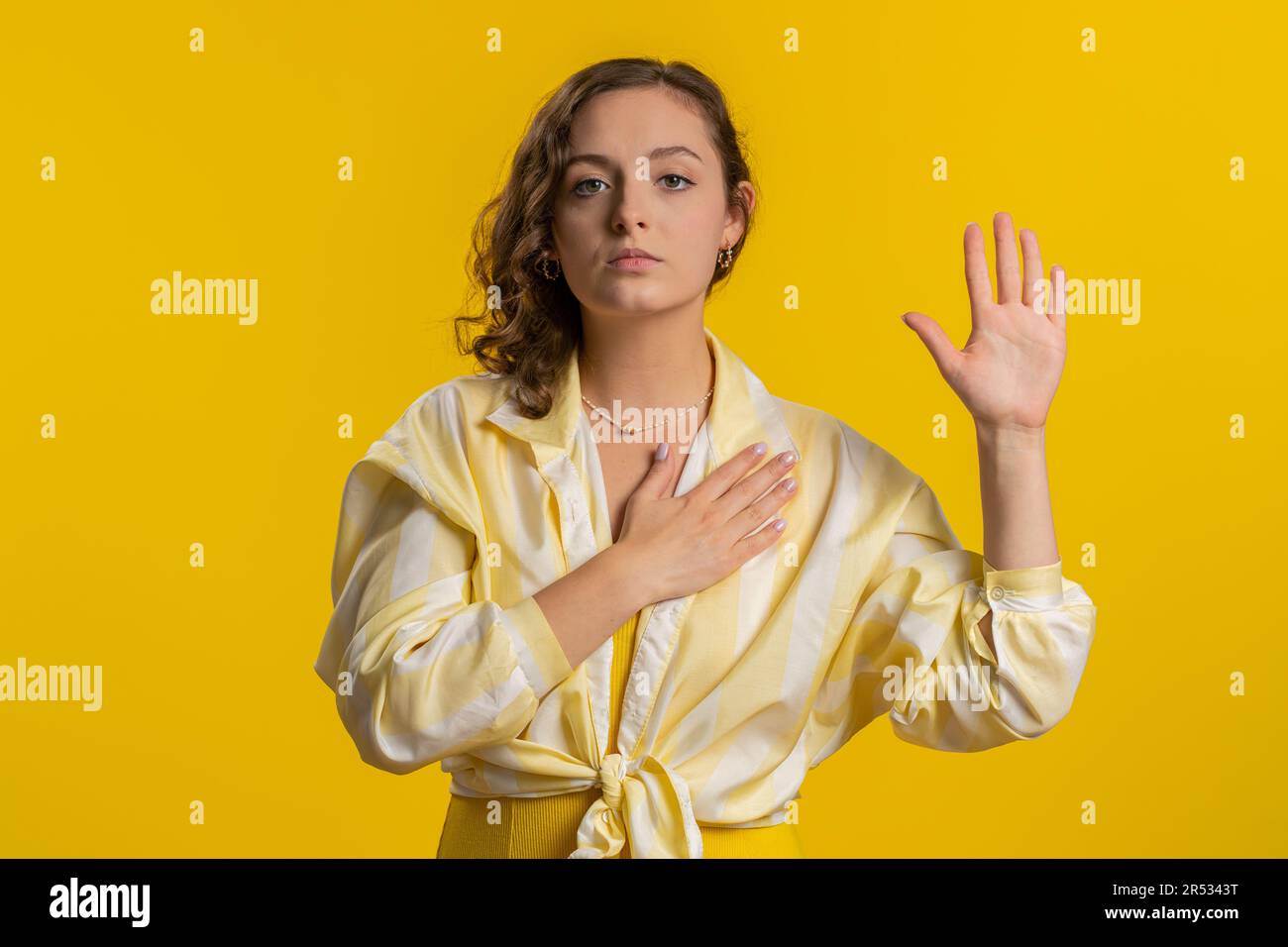 I swear to be honest. Sincere responsible young woman raising hand to ...