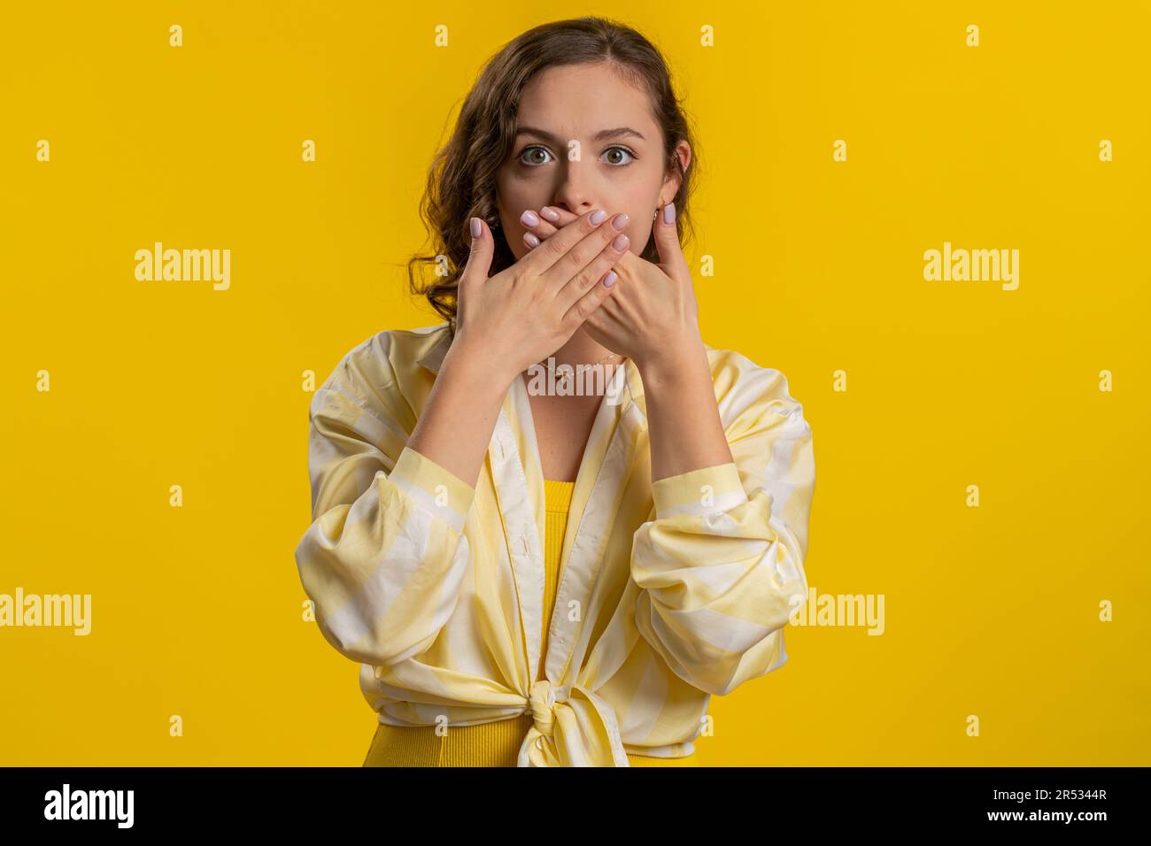 I will not say anything. Frightened woman closing mouth with hands ...