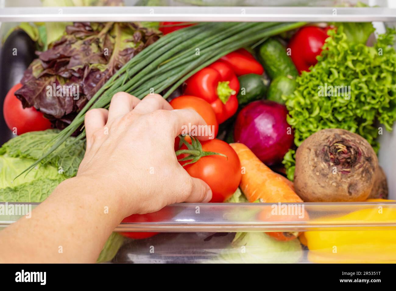 Mans hand is opening drawer of refrigerator with vegetables Stock Photo ...