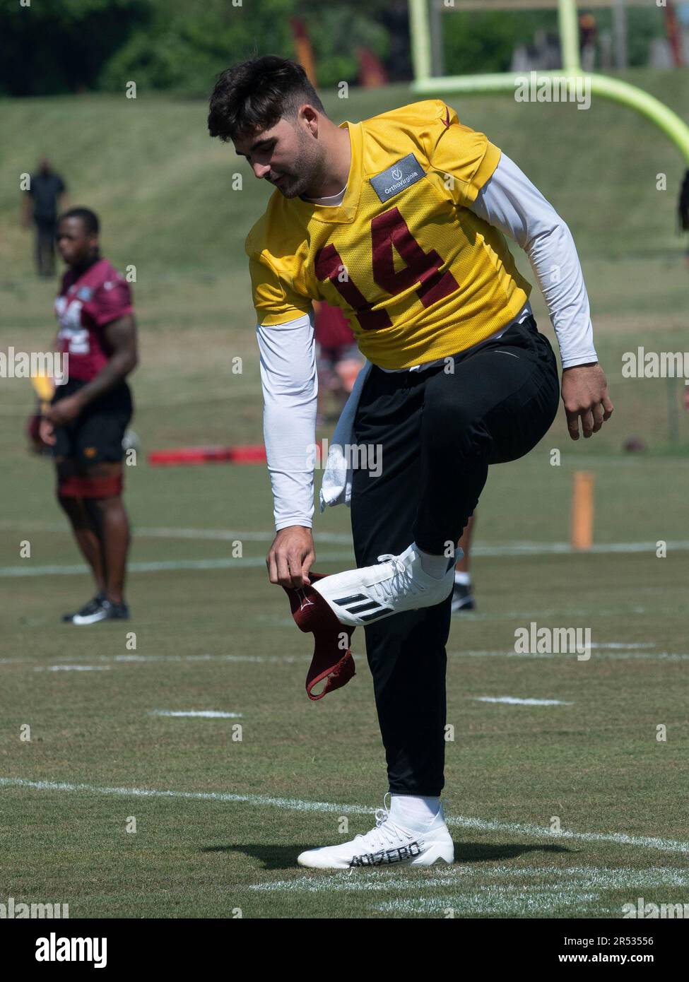Washington Commanders quarterback Sam Howell takes off an exercise band ...