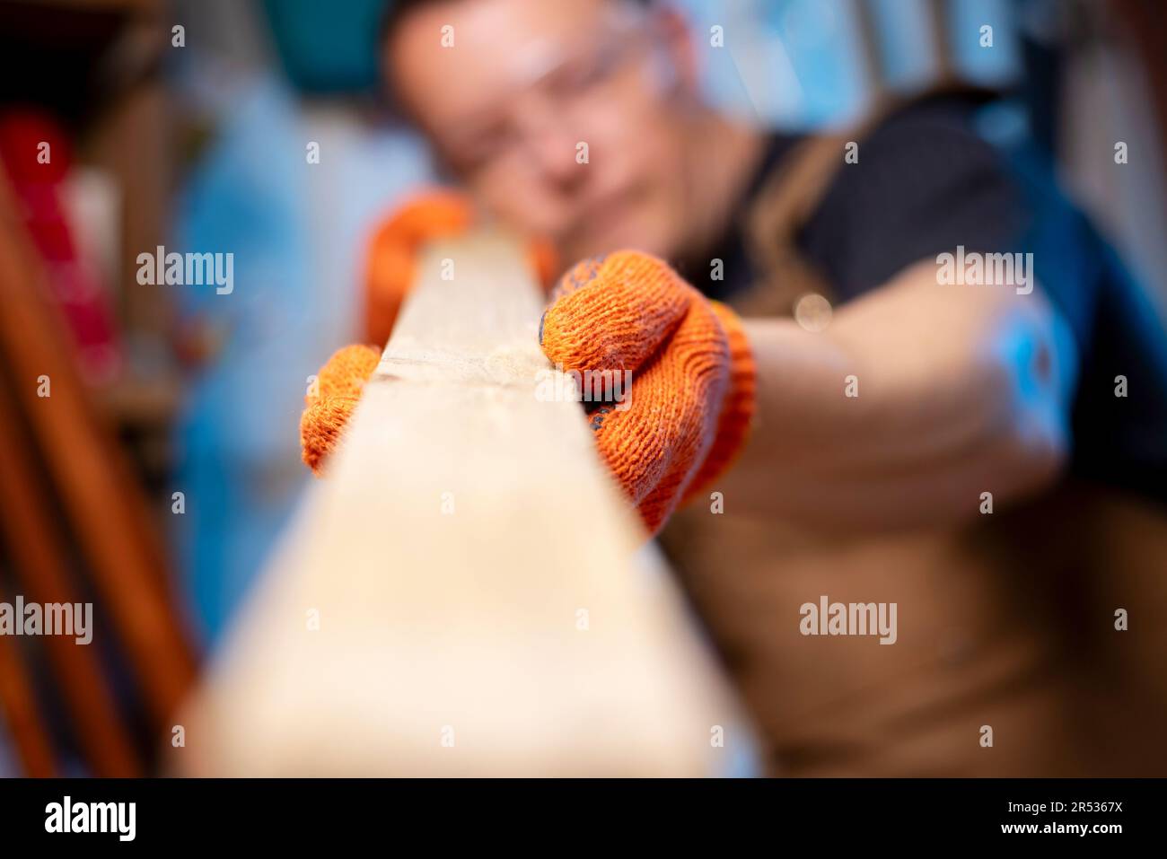 A carpenter checking smoothness of wood material. Woodworker preparing ...