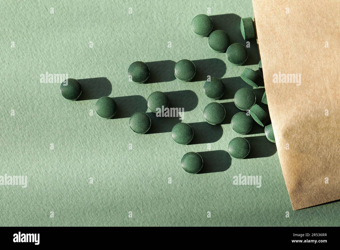 Green spirulina tablets with eco bag on green background. Natural ...