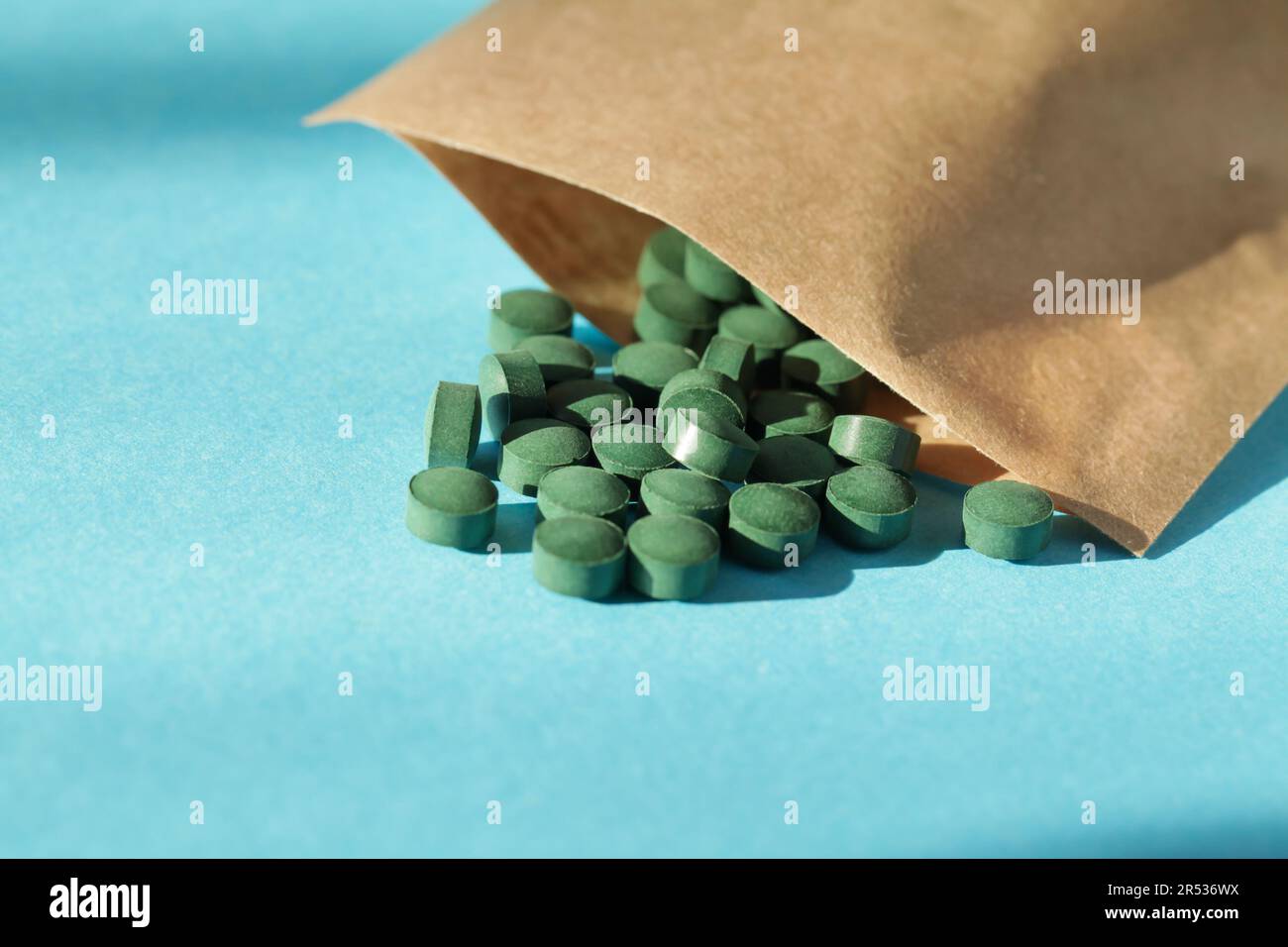 Green spirulina tablets with eco bag on blue background. Natural ...