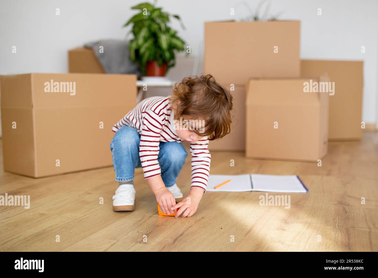 Cute Little Boy Playing With Tape Ruler At Home During Moving Day Stock ...