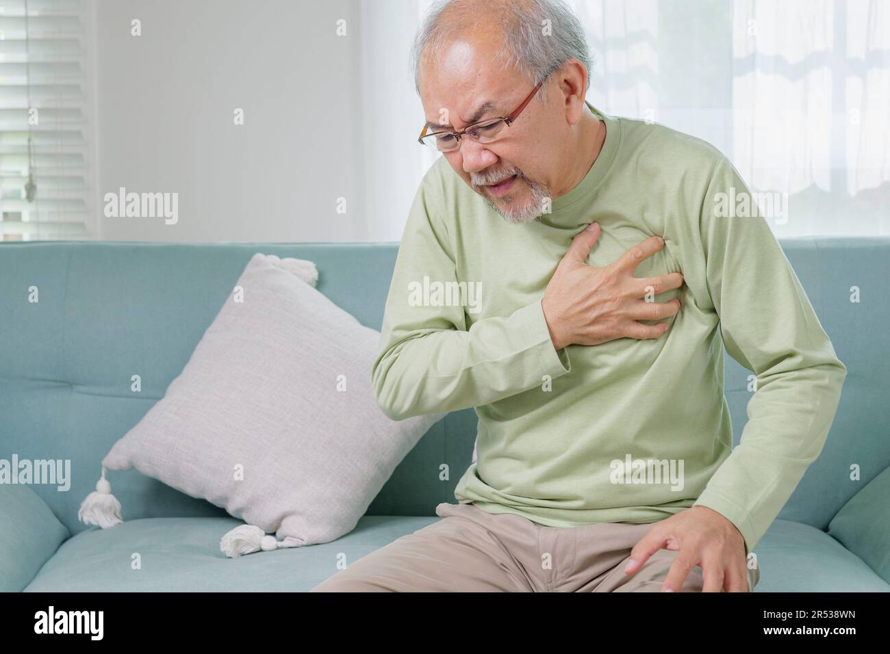 Heart attack symptoms, Senior man with heart attack suffering indoor ...