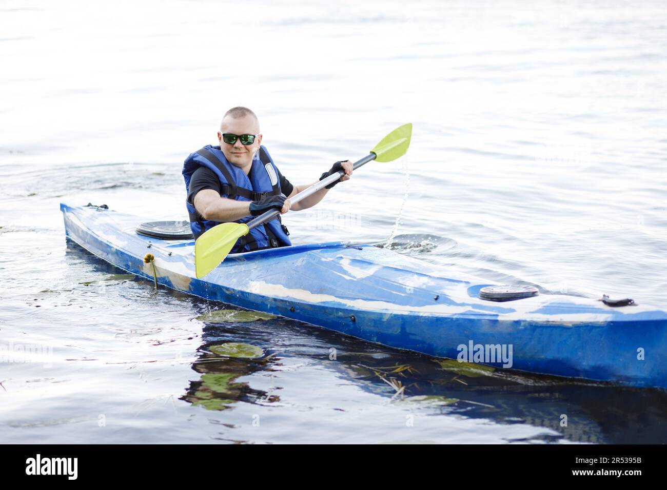 Kayaking on the river. A young Caucasian man sits in a kayak and ...