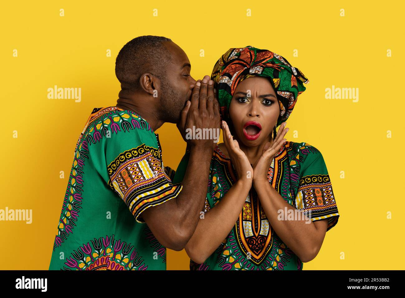 Black man sharing secrets with girlfriend, african couple on yellow ...
