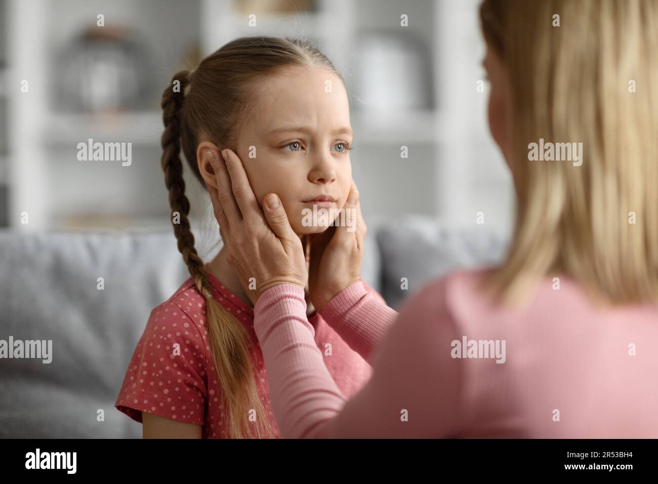 Childhood Problems Concept. Young mother comforting her sad little daughter at home Stock Photo ...