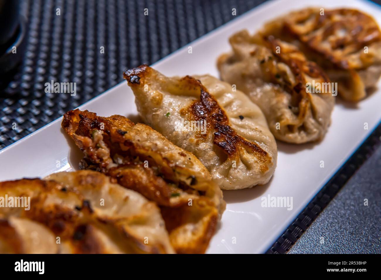 A plate full of fried momos paired with tangy, sweet, or spicy chutneys ...