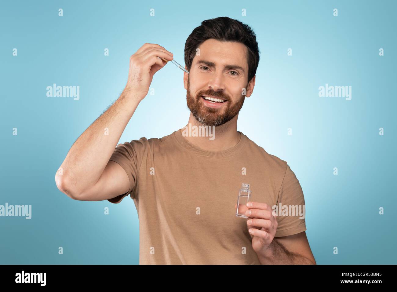 Purity in drops. Handsome middle aged man's skincare ritual with ...