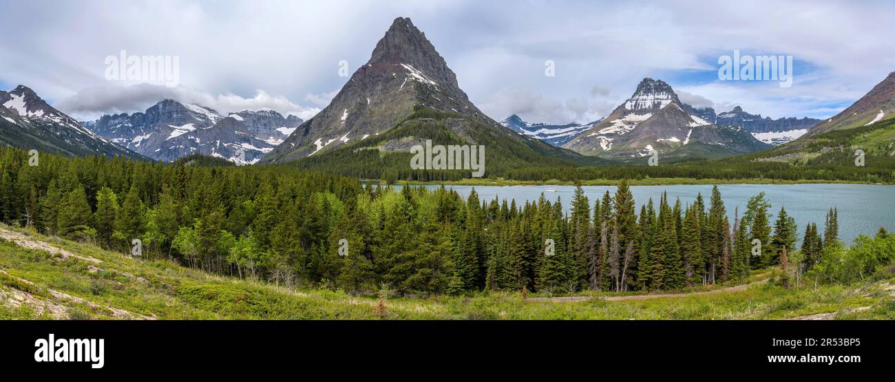 Spring Mountains at Swiftcurrent Lake - A panoramic view of rugged ...
