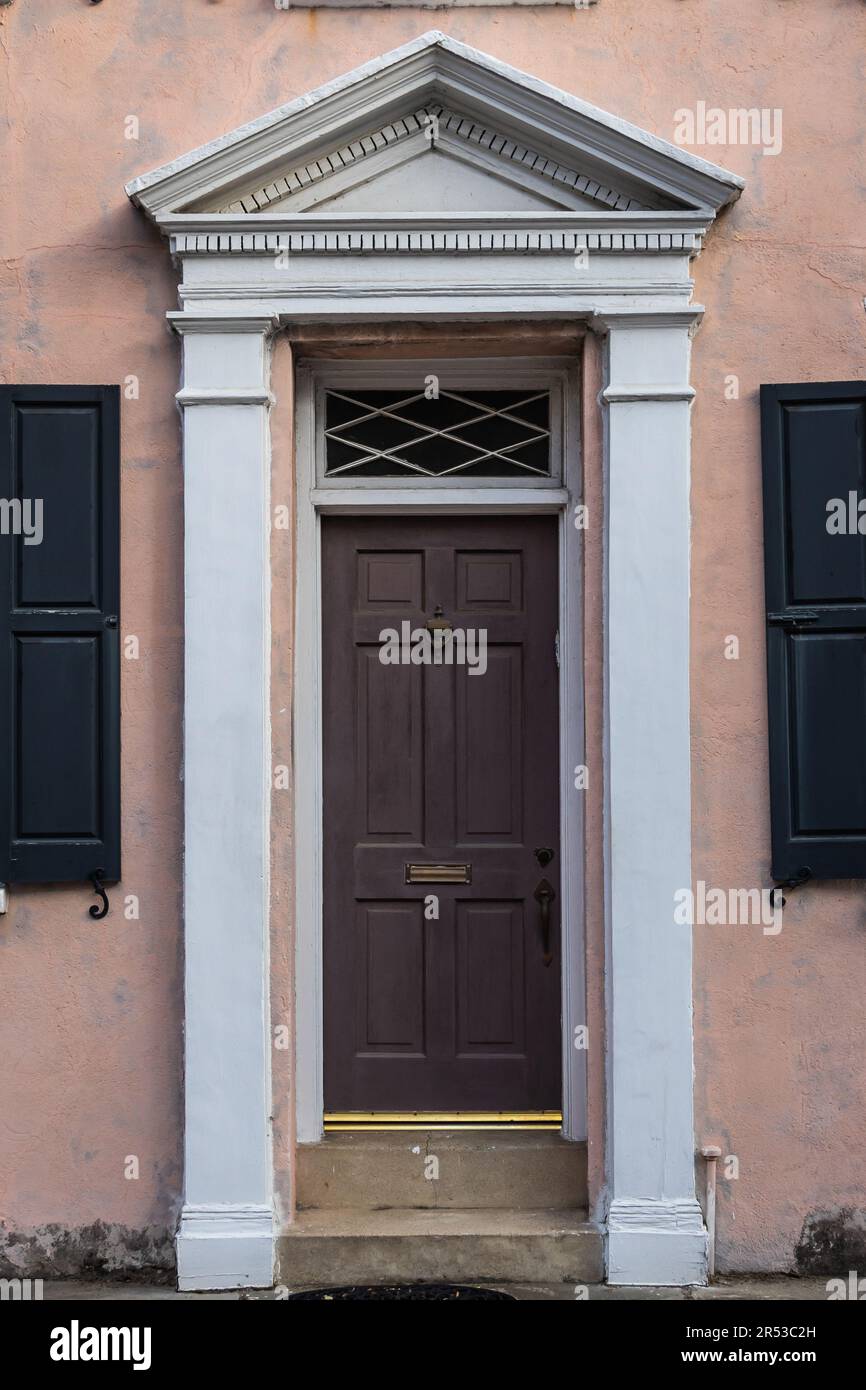 A colonial style front door with an eccentric door frame in sunlight ...