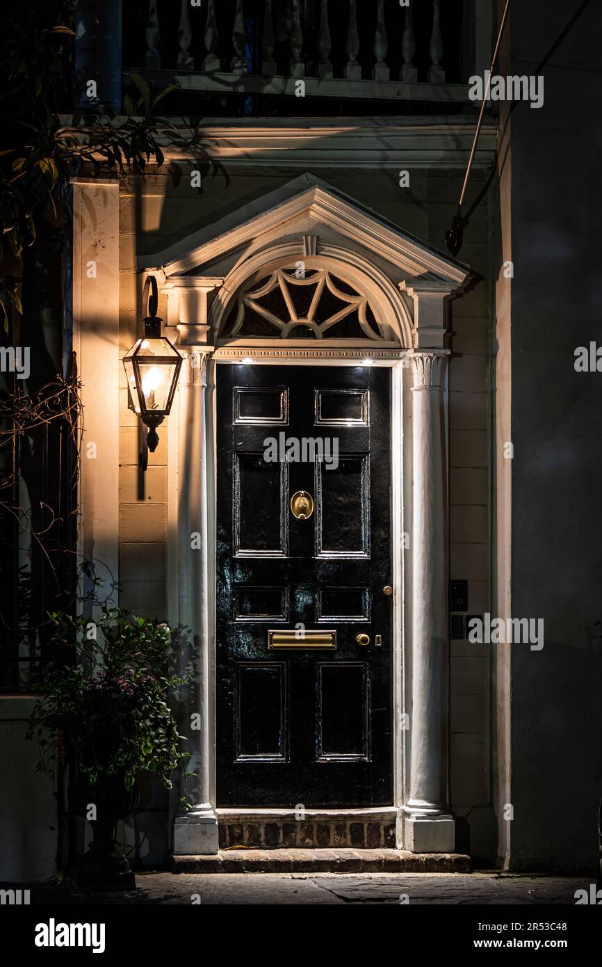 A dark and scarry black door at night illuminated by a gas flame Stock ...