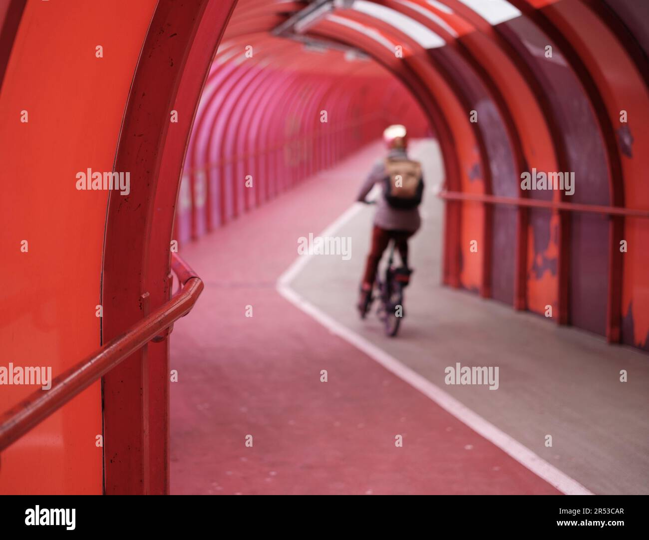 An Out Of Focus Commuter Cycling To Work Through A Pedestrian Overpass ...
