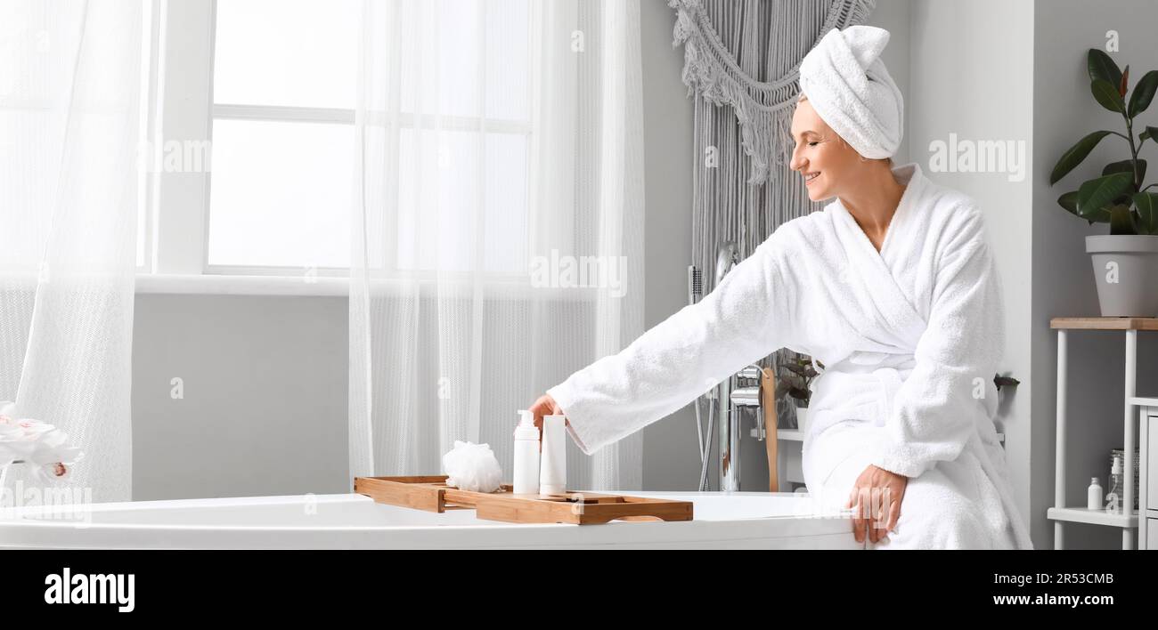 Mature woman sitting on the edge of bathtub Stock Photo - Alamy