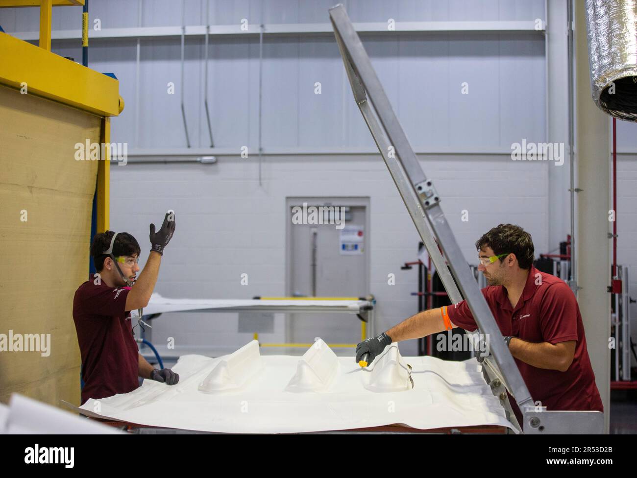 Employees discuss while prepping pieces used in interior parts at the ...